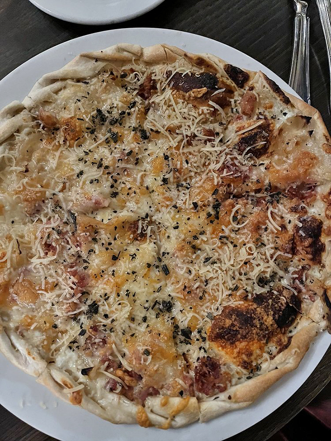 This flatbread isn't trying to be pizza's sophisticated cousin—it succeeded long ago with its perfect balance of crispy crust and savory toppings.