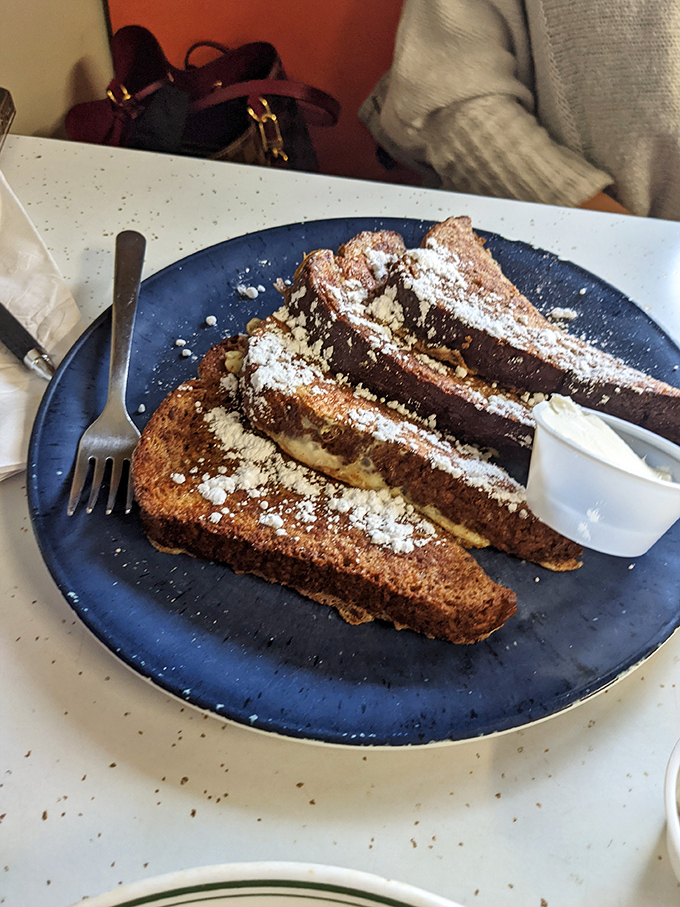 French toast that makes you question why anyone bothers with fancy brunch. The powdered sugar snowfall is just showing off.