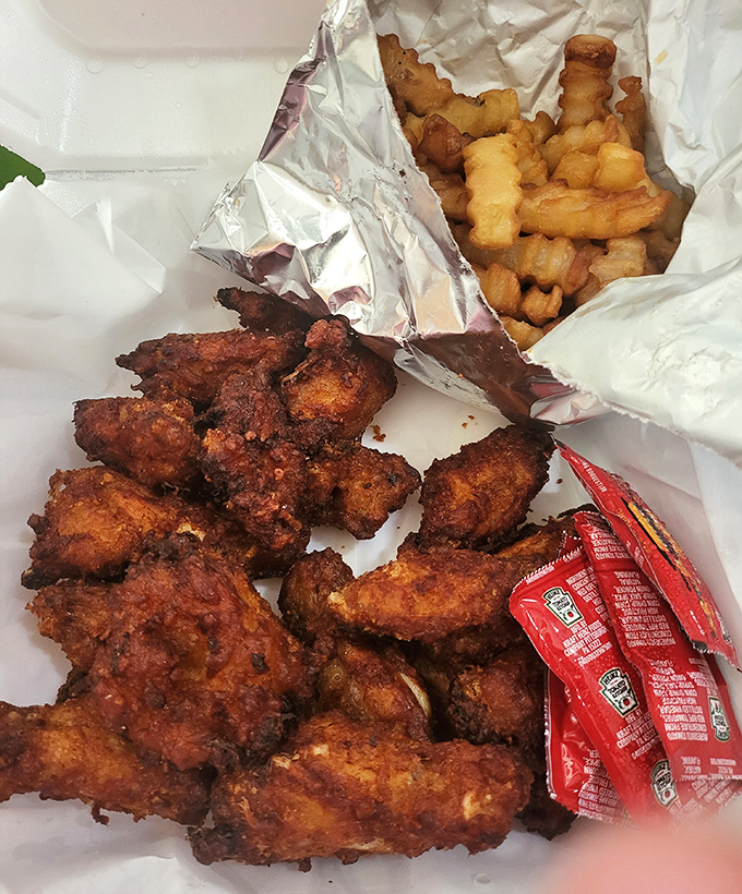 Fried chicken wings with a crackling exterior that shatters like glass, paired with crinkle-cut fries that channel your favorite childhood memories into potato form.