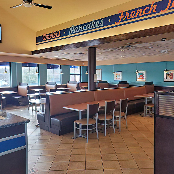 Blue accents and comfortable booths under a banner celebrating "Omelets &bull; Pancakes &bull; French Toast"&mdash;essentially the holy trinity of breakfast indulgence.