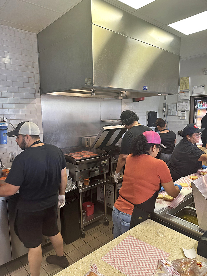 Behind-the-scenes burger ballet. The kitchen crew works with the precision of NASA engineers, ensuring each patty achieves smashed perfection.