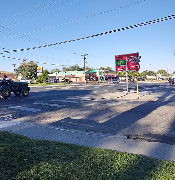 Small-town America lives on at this intersection where tractors share the road and the temperature sign reminds you it's always peach season.
