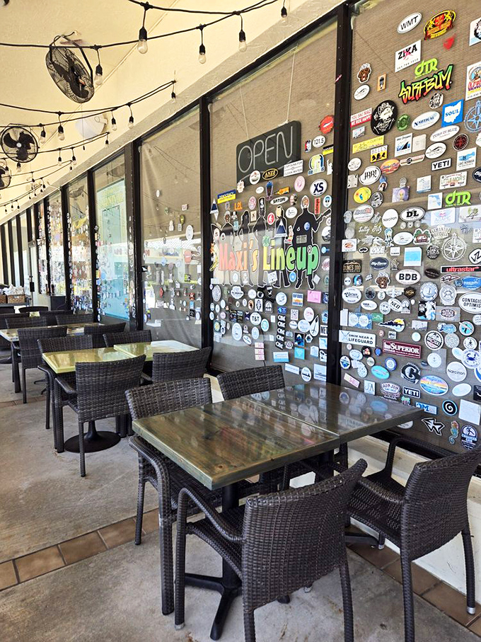 The outdoor seating area, where sticker-covered windows tell stories of visitors past and string lights promise perfect Florida evenings.