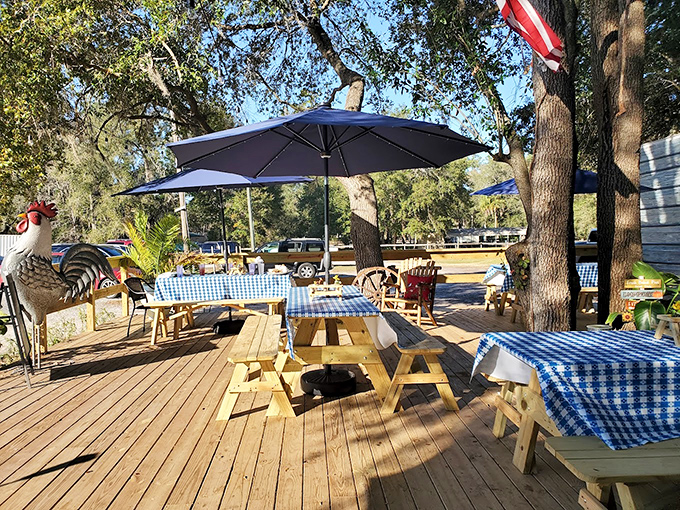 Picnic tables under umbrellas where memories are made. The rooster statue isn't just decoration&mdash;he's the unofficial greeter of this backyard paradise.