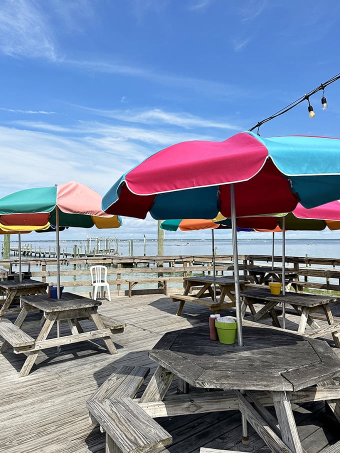 Colorful umbrellas dot the deck like a rainbow after a storm, sheltering happy diners from everything except food envy.