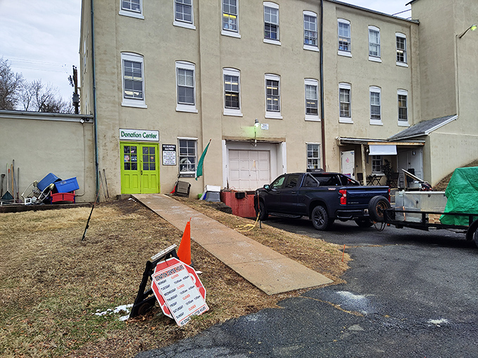 The unassuming exterior hides the wonderland within. That bright green donation door is the gateway to the circle of secondhand life.