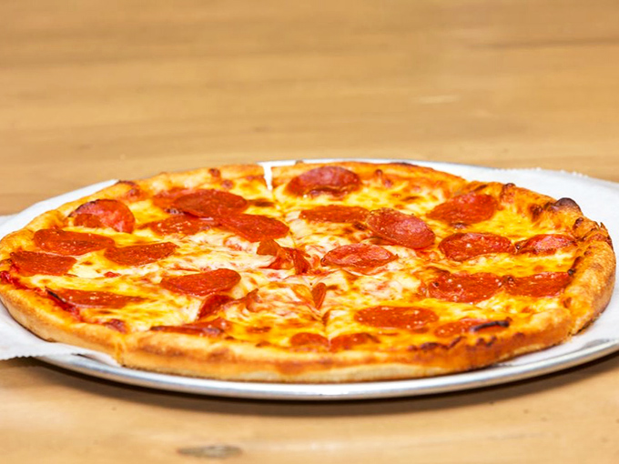 This isn't just pizza; it's a perfect circle of happiness with pepperoni polka dots that dance across a landscape of melted cheese.