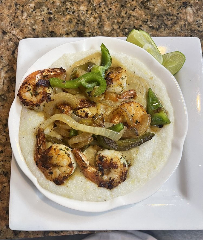 Shrimp and grits elevated to art form &ndash; plump shrimp nestled on creamy cornmeal clouds with peppers and onions dancing throughout.