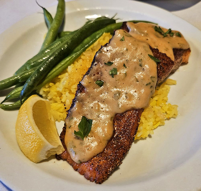 Perfectly seared fish rests on a bed of saffron rice, proving Cafe Du Berry's talents extend well beyond breakfast into dinner territory.