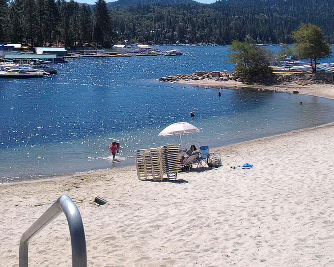 Beach chairs await sun-seekers on this hidden sandy shore, where mountain lake swimming puts ocean beaches on notice.