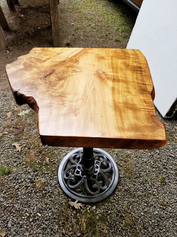 Live-edge wood transformed into functional art atop vintage ironwork. Someone's going to build their entire dining room around this conversation piece.