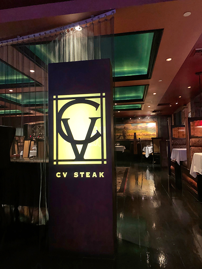 CV Steak's distinctive logo and warm interior glow hint at the perfect marriage of rustic charm and upscale dining waiting inside.