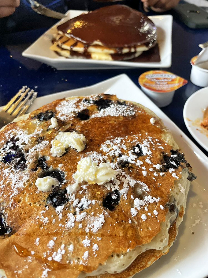Blueberry pancakes that could make you weep with joy, while that Boston cream pancake behind it is basically dessert with permission to eat it before noon.