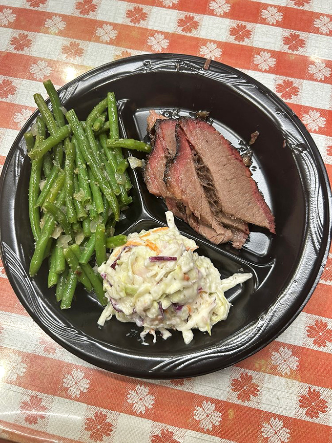 A perfect trinity: brisket with its smoky halo, green beans for virtue, and coleslaw for crunch&mdash;the holy balance of a proper Texas plate.