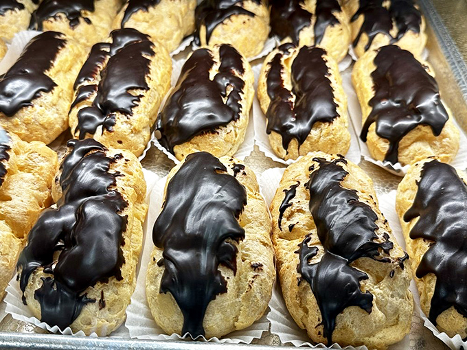 Chocolate eclairs lined up like soldiers ready for delicious battle. Resistance is futile against these cream-filled, chocolate-dipped wonders.