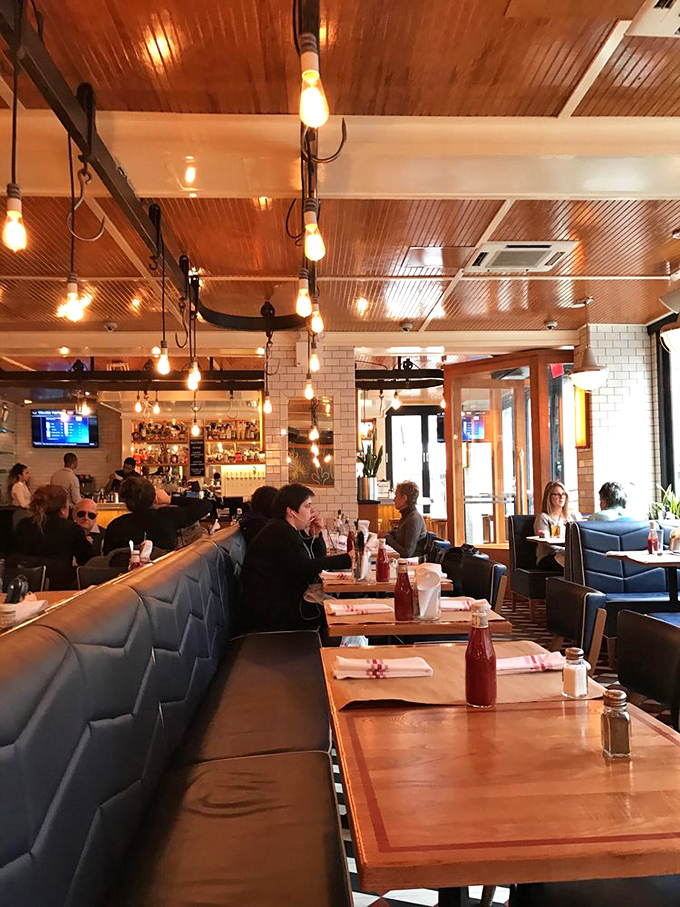 Booths lined with expectant diners about to experience napkin-requiring deliciousness. Those ketchup bottles stand ready for action.
