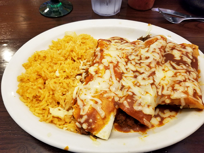 Enchiladas smothered in sauce and melted cheese alongside golden rice. This plate doesn't just satisfy hunger&mdash;it resolves it completely with warm, comforting Mexican goodness.