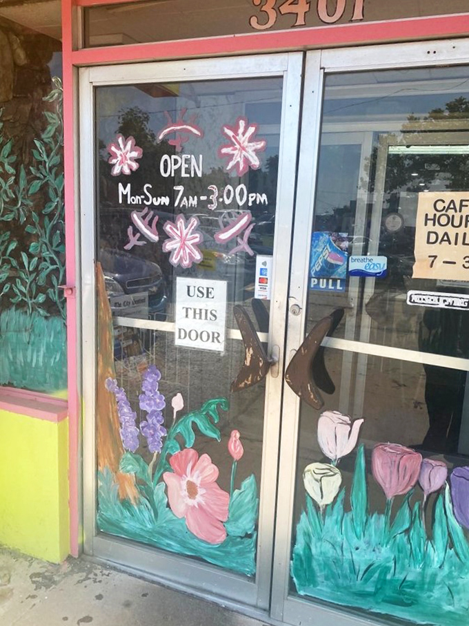 Hand-painted flowers frame the entrance like a cheerful welcome committee, announcing hours that respect both early birds and late risers.