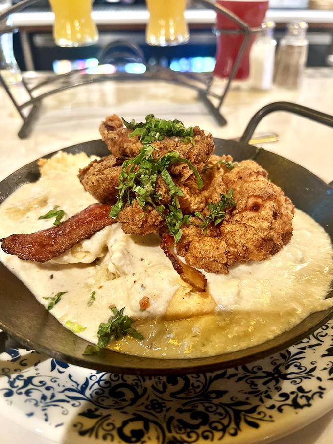 Southern comfort reimagined&mdash;crispy fried chicken nestled on creamy grits like it's found its soulmate after years of searching.