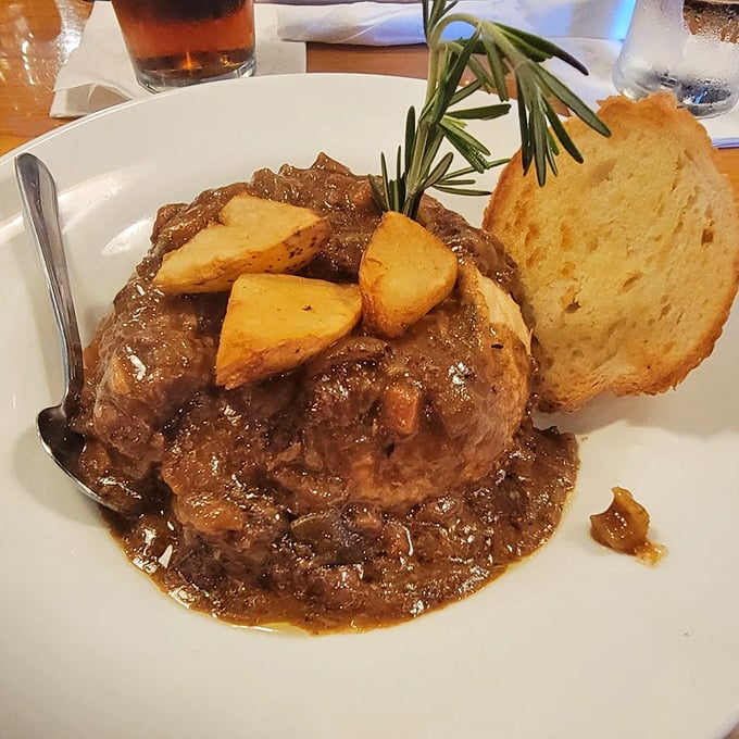 Guinness stew that warms the soul. Tender chunks of beef swimming in rich gravy with roasted potatoes and a sprig of rosemary for aromatic flair.