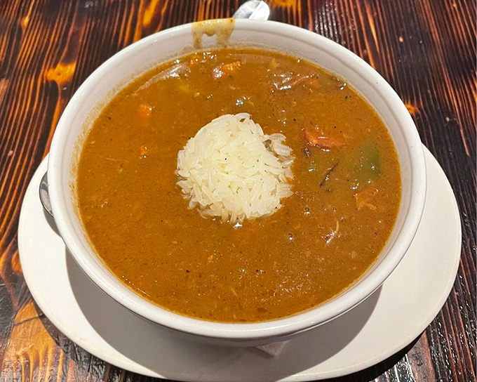 Gumbo with a perfect rice island rising from the flavorful depths. This bowl contains generations of Southern cooking wisdom in every spoonful.