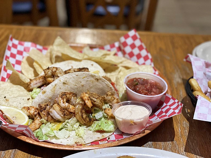 Shrimp tacos served with a side of tortilla chips and dipping sauces. A handheld vacation that requires no passport&mdash;just napkins
