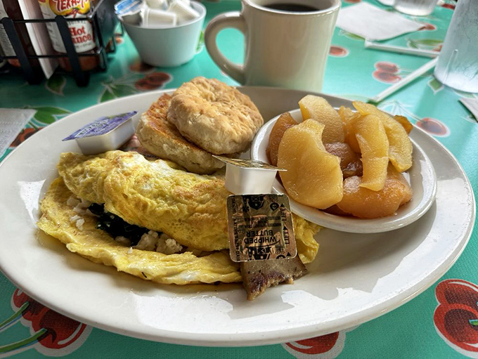 Breakfast that doesn't know the meaning of "too much"—omelet, biscuit, and applesauce in perfect harmony. The morning meal as a three-act play.