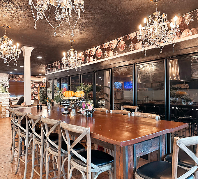 The communal table beneath crystal chandeliers creates that perfect paradox&mdash;farmhouse rustic meets unexpected elegance.