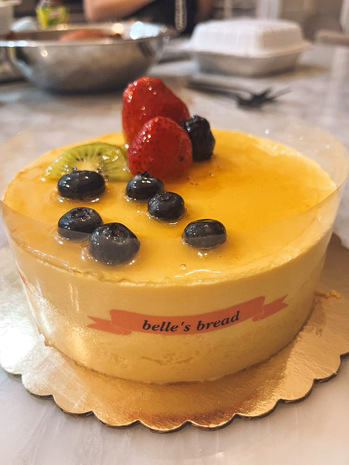 This mango mousse cake glistens like Ohio sunshine in dessert form, topped with berries that pop like edible jewels.