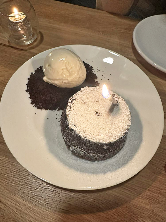Molten chocolate cake with flickering candle - dessert theater that never fails to create magical dining moments.