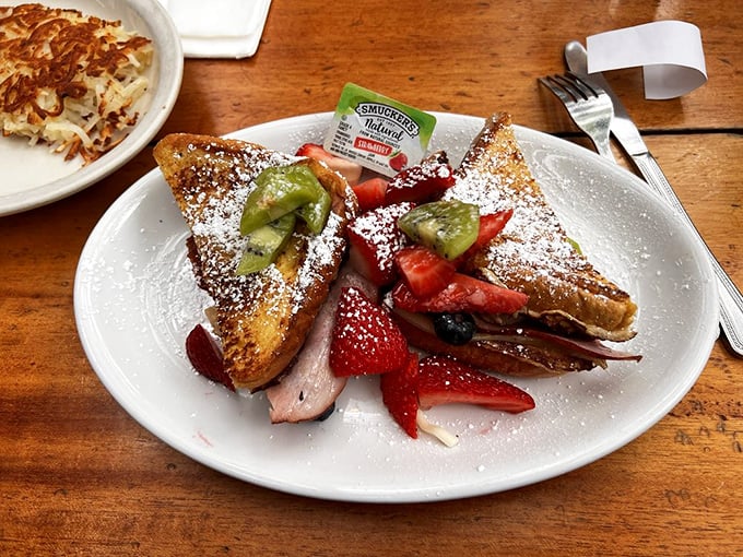 French toast transformed into a Monte Cristo sandwich, dusted with powdered sugar and fresh fruit&mdash;breakfast and dessert having a delicious identity crisis.