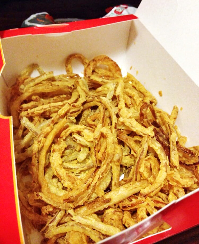 Onion rings with architectural integrity&mdash;crispy golden circles that snap rather than slump, leaving you with empty boxes and full hearts.