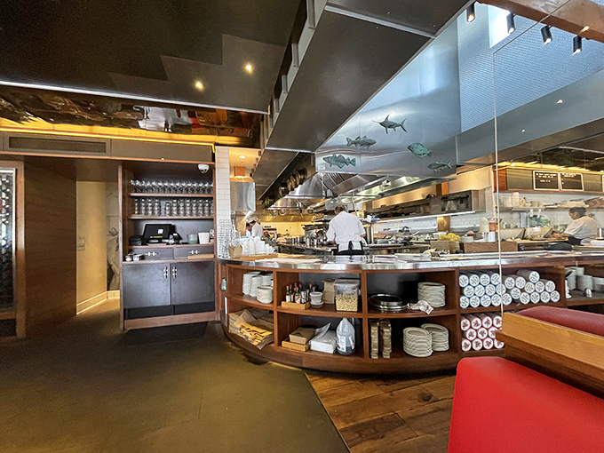 The open kitchen reveals the organized chaos behind your seafood feast. Those hanging fish aren't just decoration—they're a promise of what's to come.