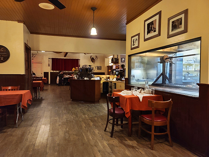 Red tablecloths against wooden floors create that classic steakhouse vibe that says, "Yes, we've been doing this right for decades."