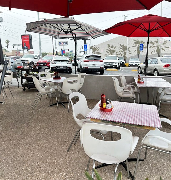 Outdoor dining with red umbrellas and checkered tablecloths. Even the patio furniture looks like it could tell stories about the changing Los Angeles landscape.