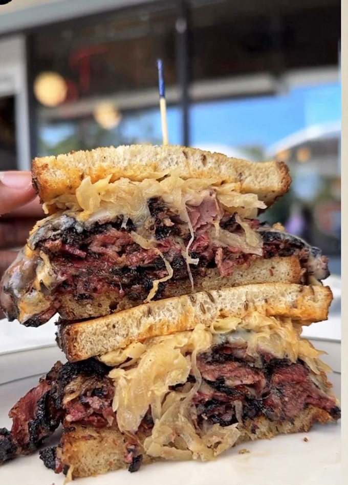 This isn't just a Reuben; it's edible architecture&mdash;layers of pastrami, sauerkraut, and Swiss creating a towering monument to deliciousness.