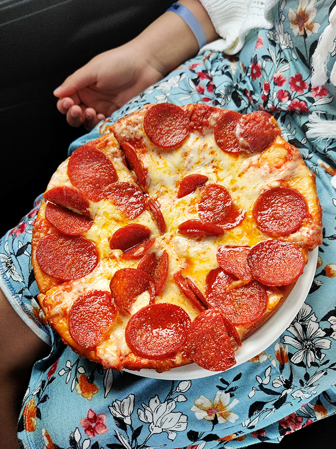 This pepperoni pizza resting on a floral dress is what happiness looks like on a plate—simple, abundant, and completely unpretentious.
