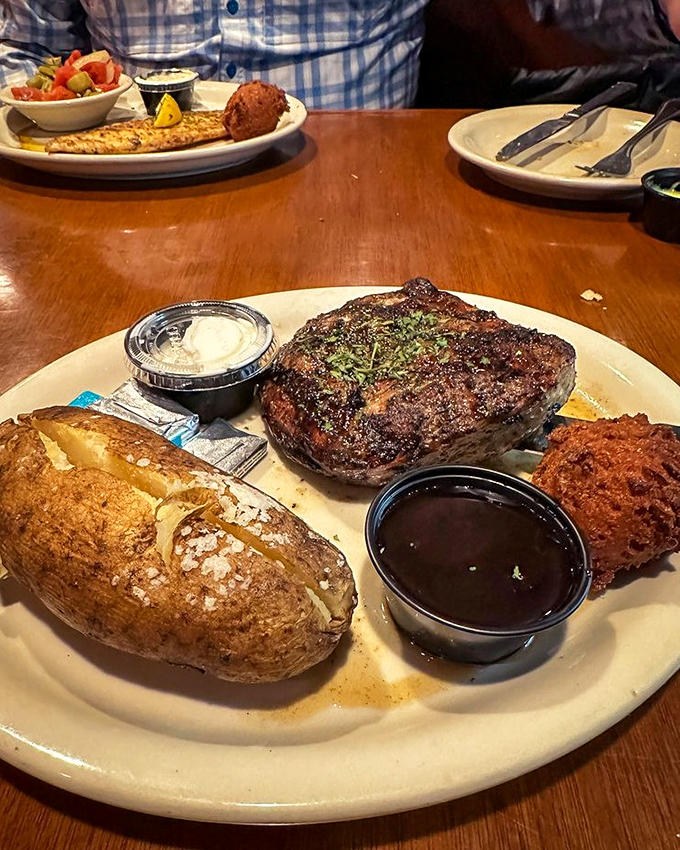 A steak that would make Ron Swanson weep with joy, accompanied by a baked potato that's seen things in the oven.