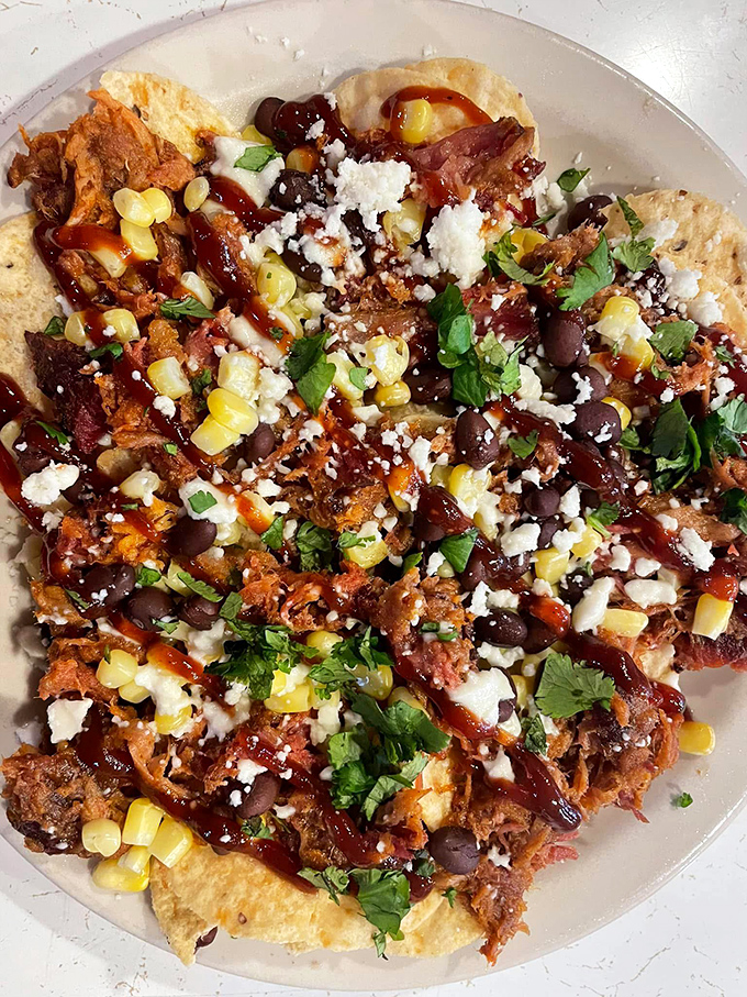 Pulled pork nachos that blur the line between appetizer and main event &ndash; a glorious mess of textures and flavors worth every napkin.