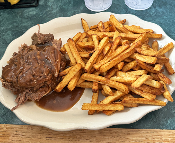 Pulled pork swimming in rich gravy alongside perfectly crisp fries. The plate practically whispers, "Nap time follows this meal. Don't fight it." 