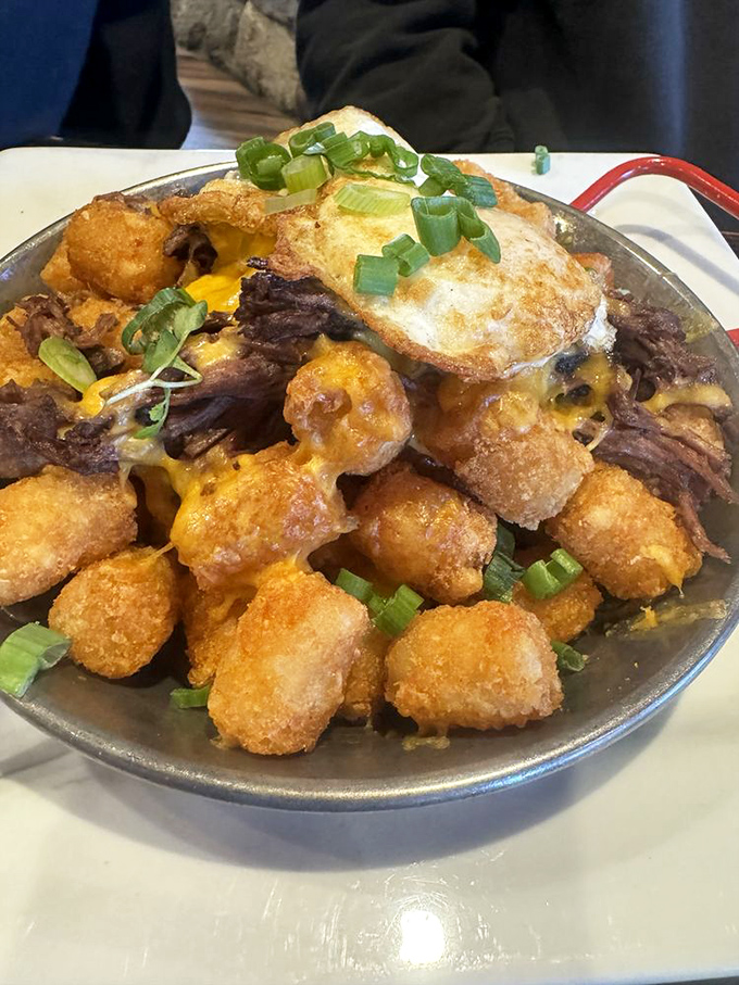Tater tot nachos that blur the line between appetizer and religious experience, topped with an egg because why not go all in?
