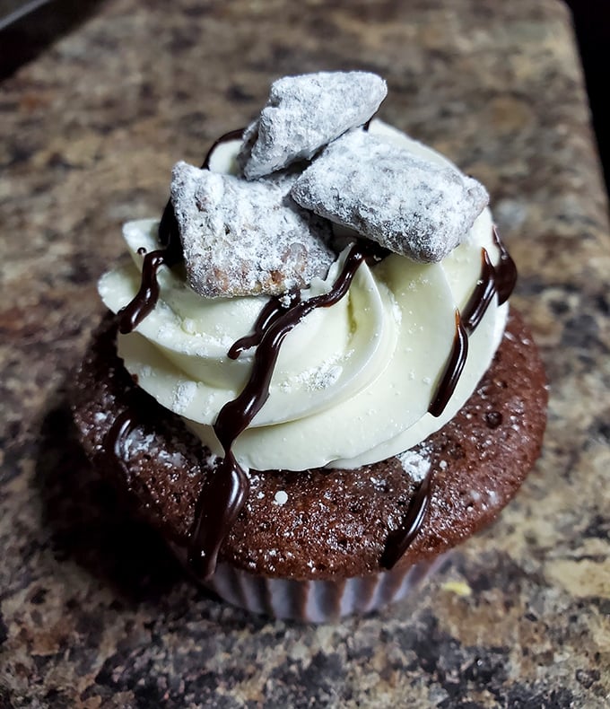 Powdered sugar-dusted treats atop vanilla frosting create a textural symphony that makes this chocolate cupcake the dessert equivalent of a standing ovation.