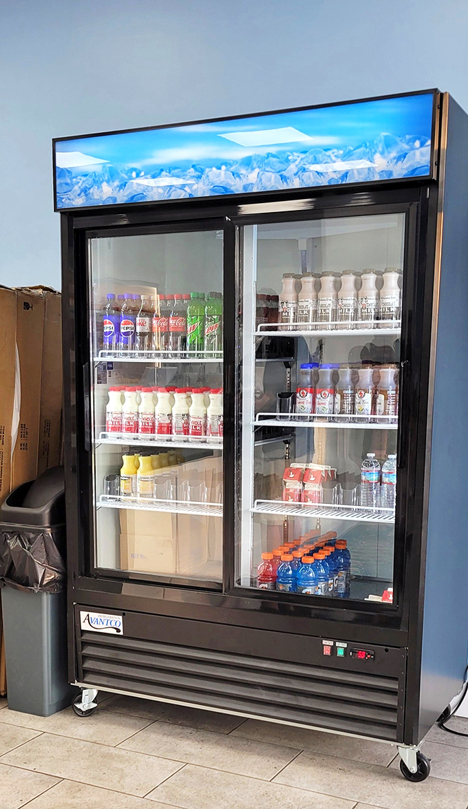 The drink cooler stands sentinel, offering hydration options for those who understand that proper donut appreciation requires liquid accompaniment.