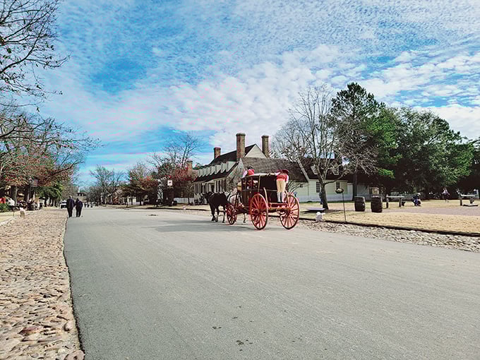 A bright red carriage rolls down the historic thoroughfare—the 18th-century equivalent of driving a Ferrari through town, but with considerably more hay.