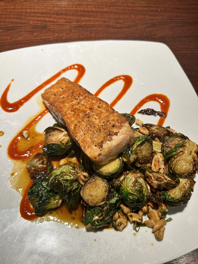 Salmon that's not just cooked—it's respected, perched atop Brussels sprouts with a sauce that zigzags with purpose and flavor.