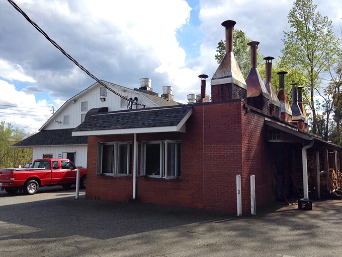 The smokehouse stands like a brick sentinel, its chimneys releasing the intoxicating aroma that's been seducing passersby for decades.
