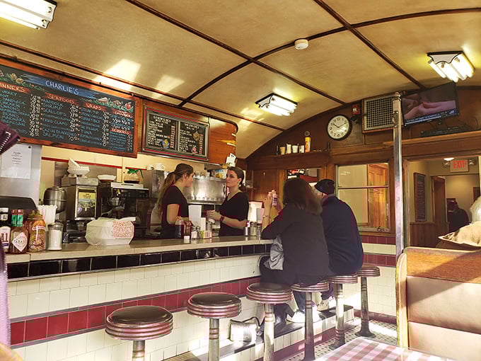 The curved ceiling of the original diner car frames the counter where magic happens&mdash;servers and cooks working in the practiced rhythm of diner perfection.