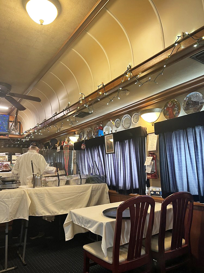 Behind every great dining car is a dedicated crew. The curved ceiling and decorative plates above create the perfect backdrop for mealtime magic.