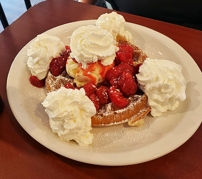 A waffle that's throwing a party and invited all the best guests: strawberries, whipped cream, and your imminent food happiness.