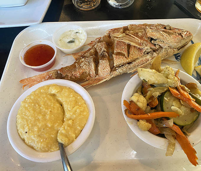 A whole fried fish presented with the confidence of a chef who knows exactly what you need before you do. Those sides aren't afterthoughts&mdash;they're co-stars.